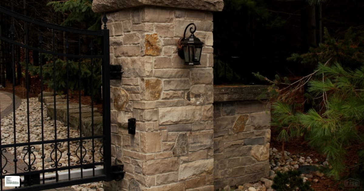 Stone gate with accent lighting with Stone Siding by Masonal Stone Inc