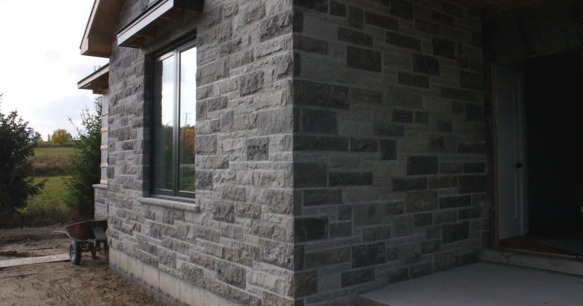 Stone sided house under construction with Stone Siding by Masonal Stone Inc
